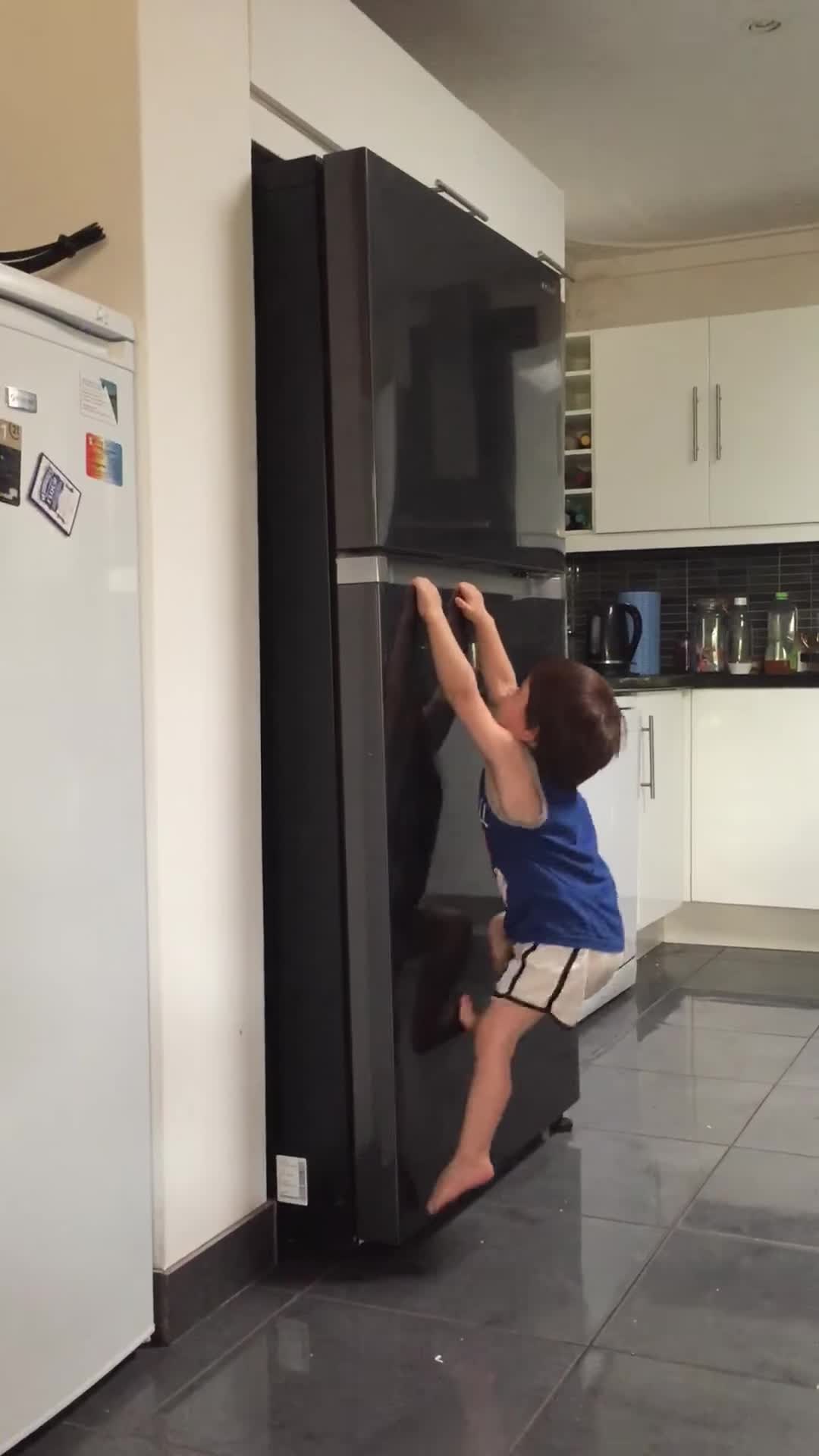 Cute spider man toddle try to climb the fridge