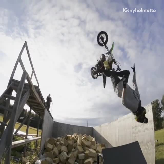 Guy motorcycle dirt bike back flip into foam pit almost gets hit by bike