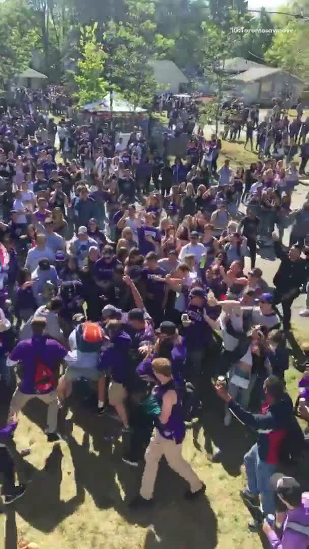 Shirtless man does back flip into crowd in purple